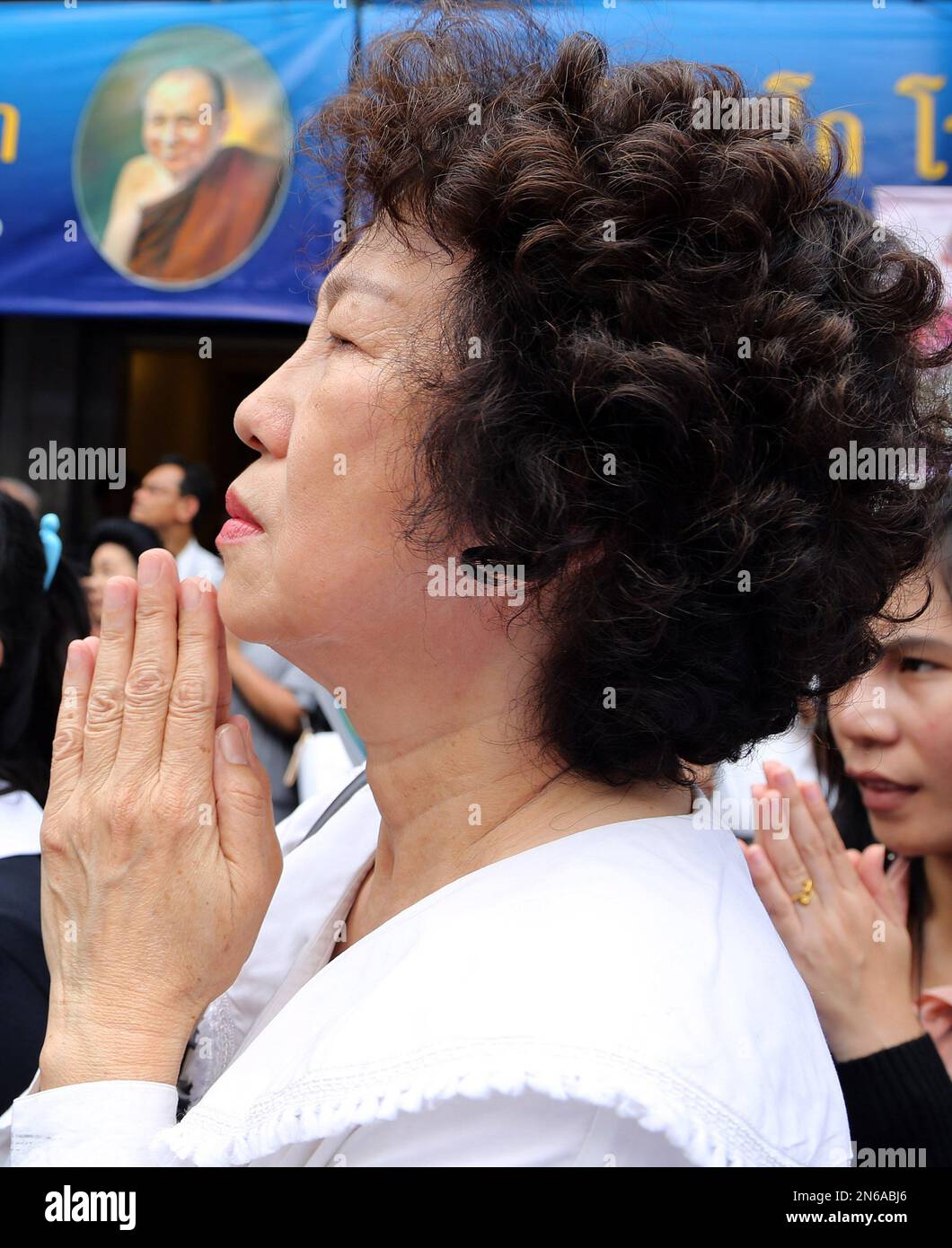 A Thai woman prays as the motorcade of the body of Thailand's Supreme ...