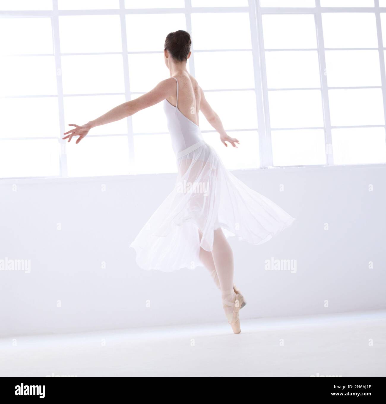 Living art. Graceful young ballerina in white dancing en pointe Stock ...
