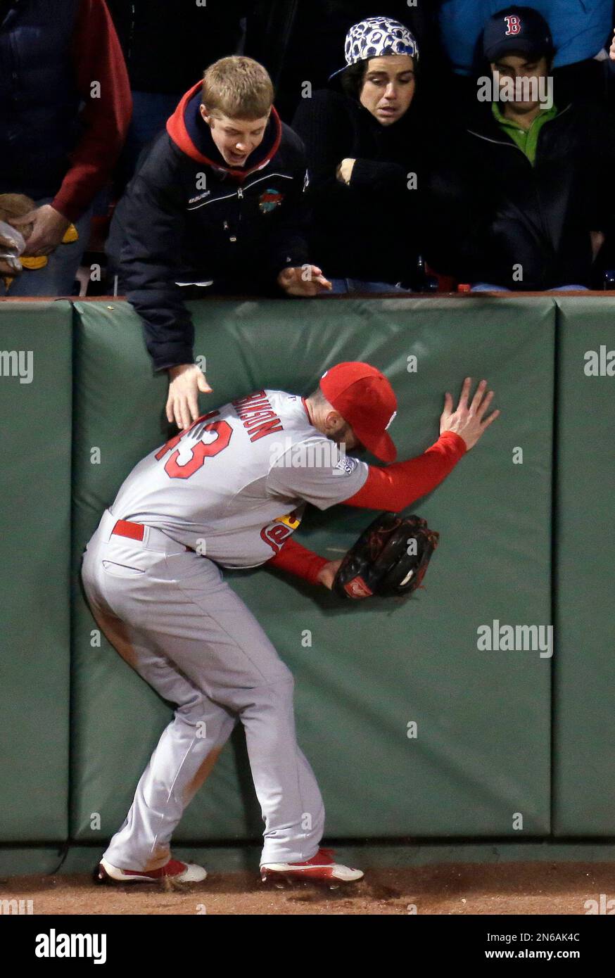 St. Louis Cardinals' Shane Robinson runs into the wall after catching a ...
