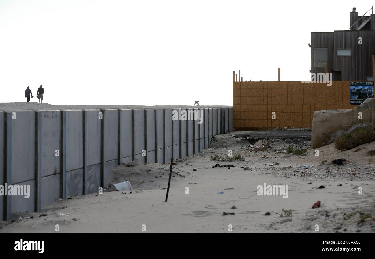 People walk on a raised section of beach in the Belle Harbor section of ...