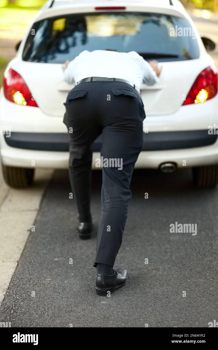 Pushing his car onto the curb. Rear view of a man pushing his car Stock ...