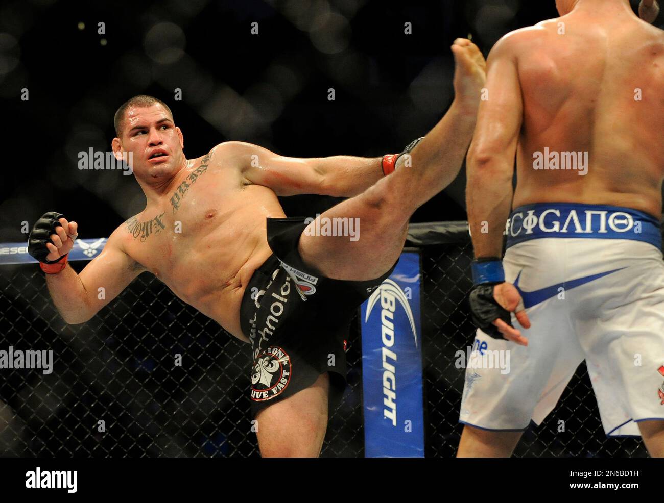 UFC heavyweight champion Cain Velasquez, left, delivers a kick to ...