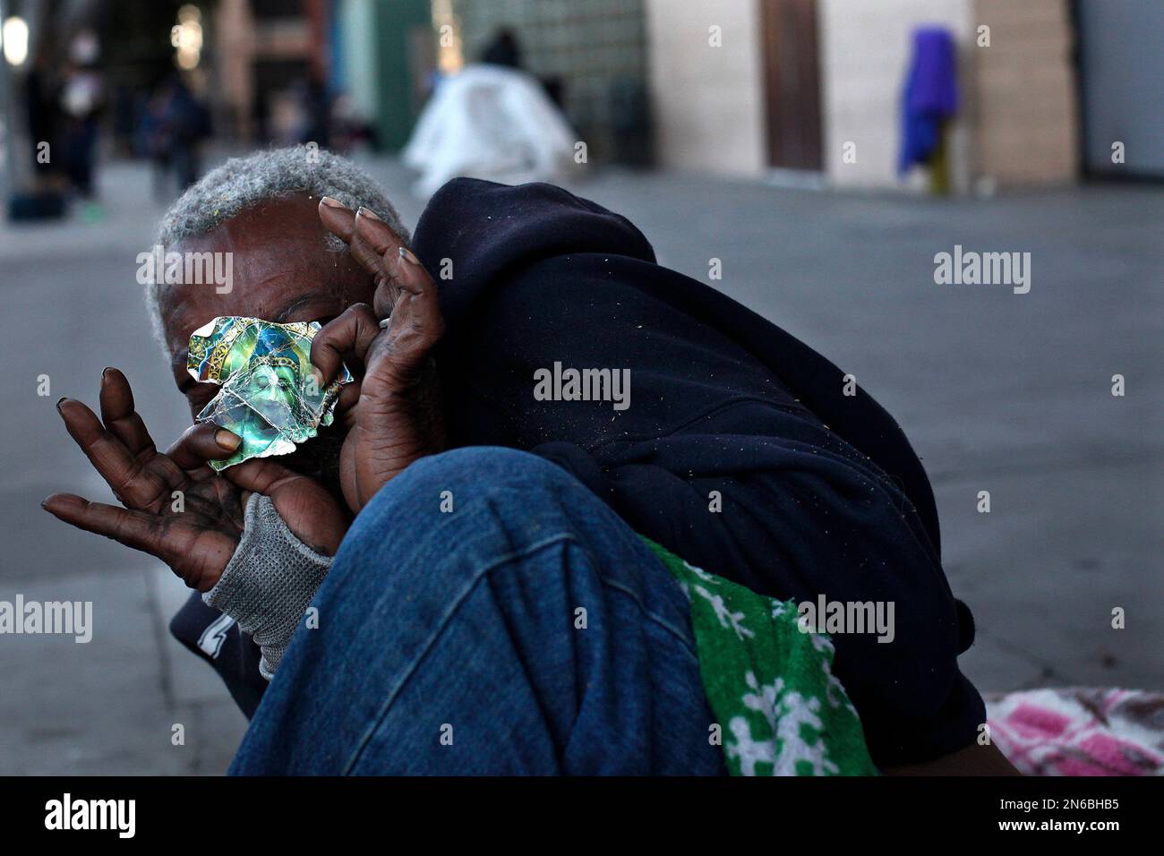 A homeless man holds a torn piece of paper showing a painting of the ...