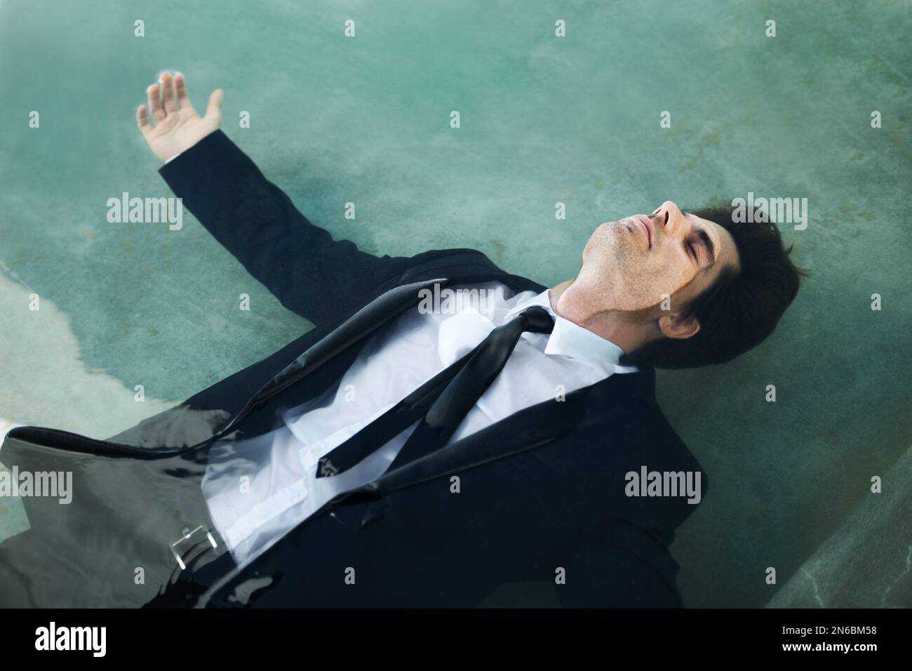 This boat is about to sink...A young businessman wearing a suit while ...