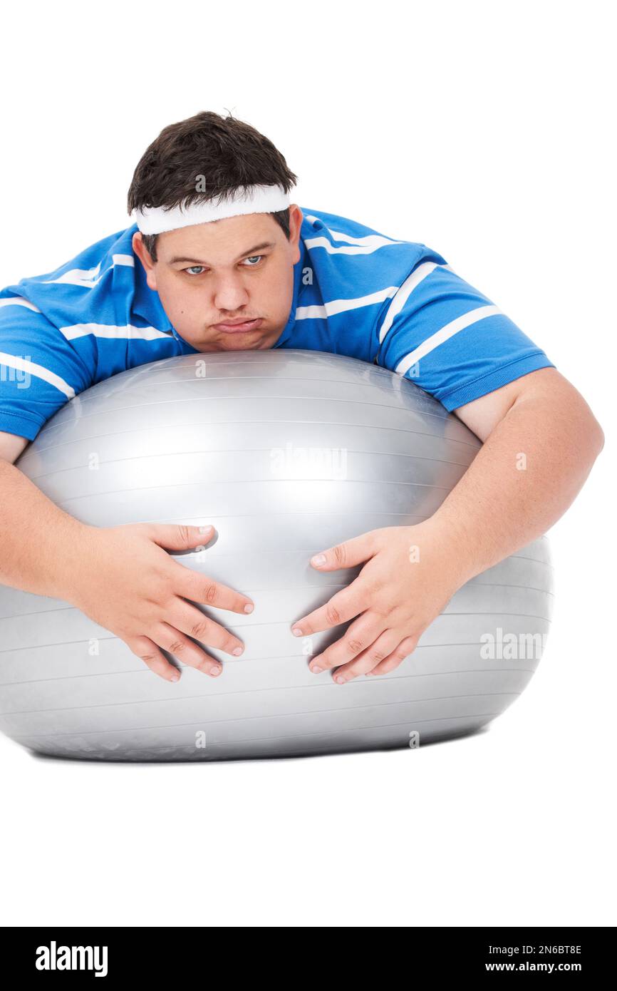 Down for the count. A overweight young man collapsed on an exercie ball ...
