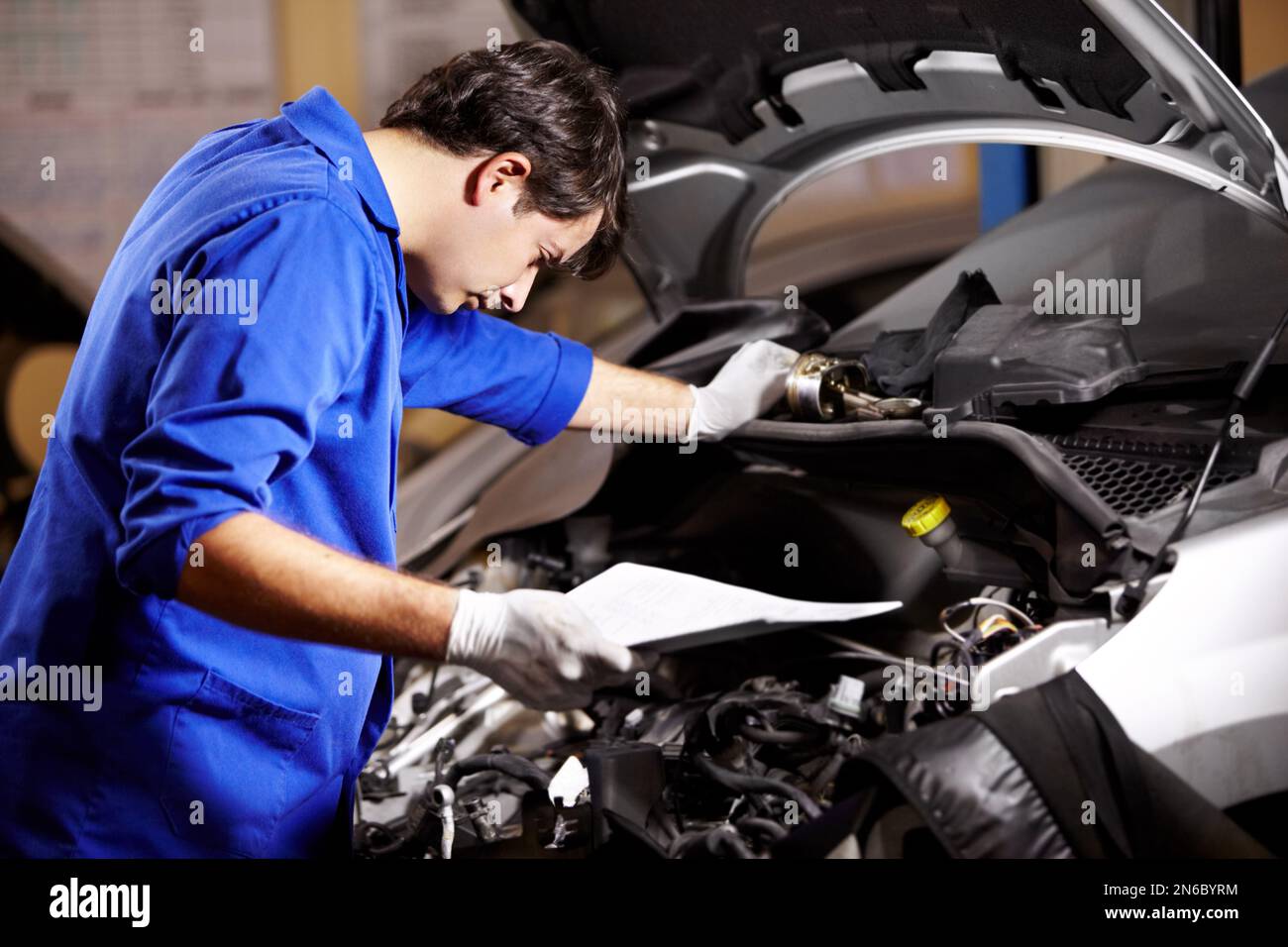 These readings say everything is fine. A male mechanic holding some ...