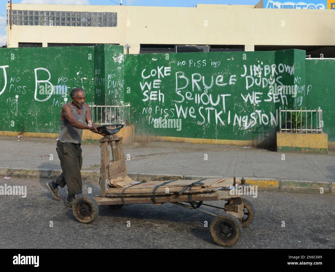 In this Oct. 12, 2013 photo, a market vendor wheels a handcart down a ...