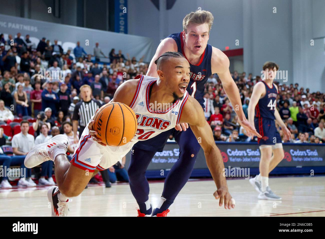 Loyola Marymount guard Cam Shelton, front, falls after driving past ...