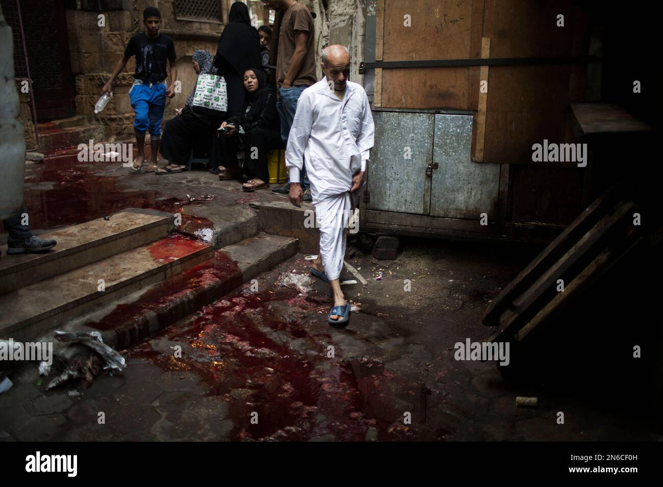 A man walks through an alley covered with bloodstained water on the ...