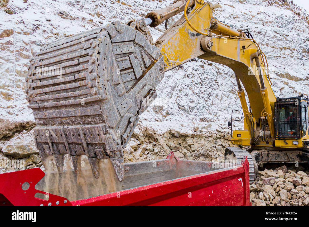 Powerful crawler excavator loads the earth into a dump truck against ...