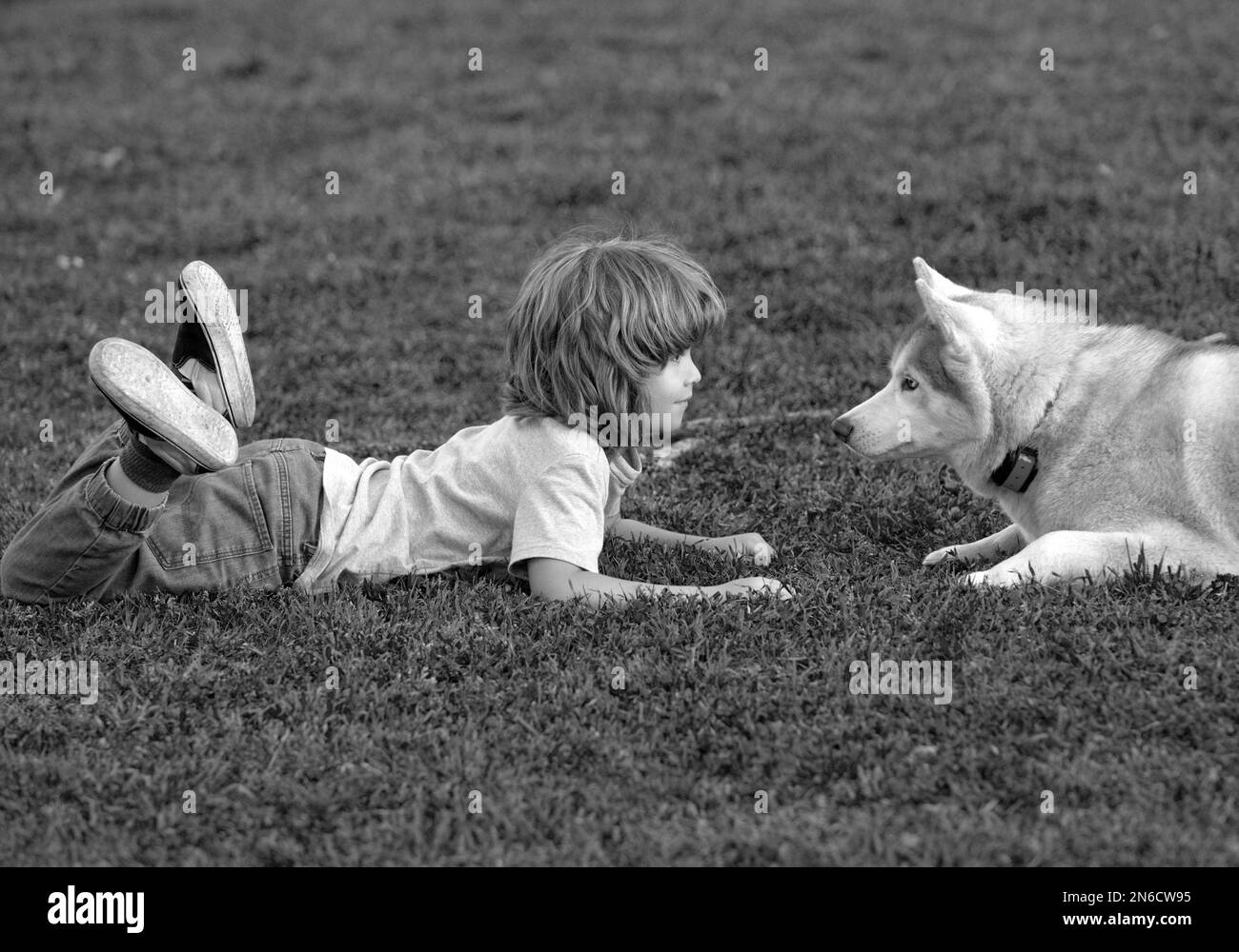 Child with a dog. Kid with a puppy dog outdoor playing at backyard lawn ...