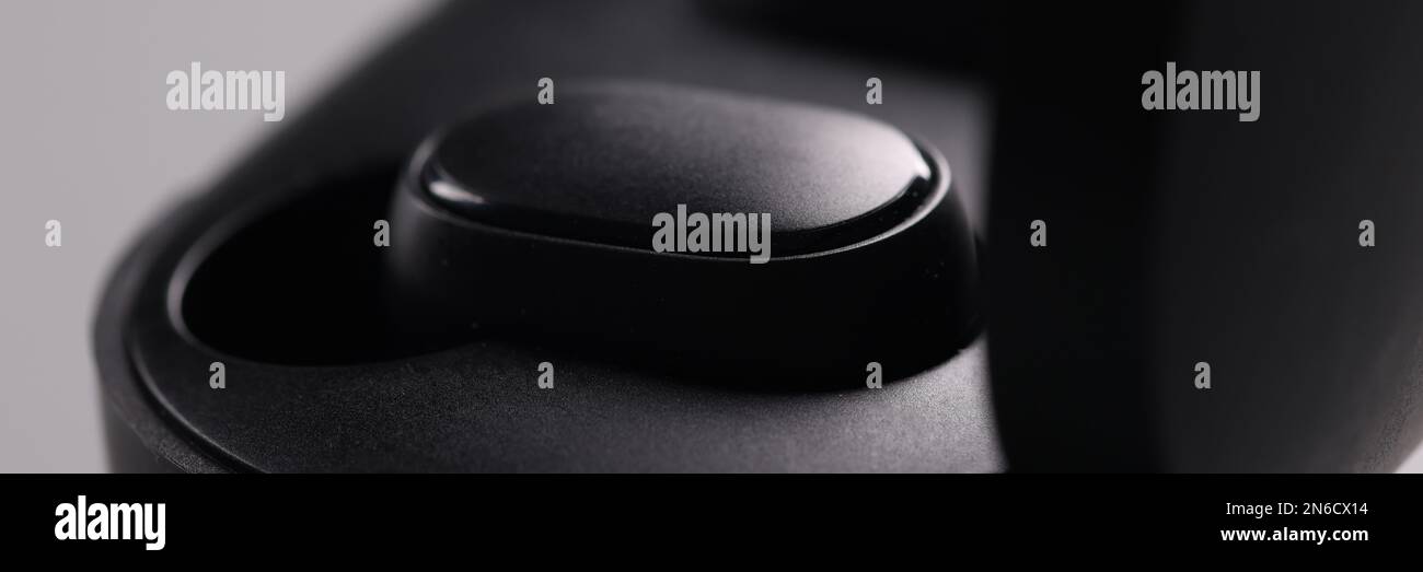 Black electronic bluetooth headphones and technical cases on grey ...