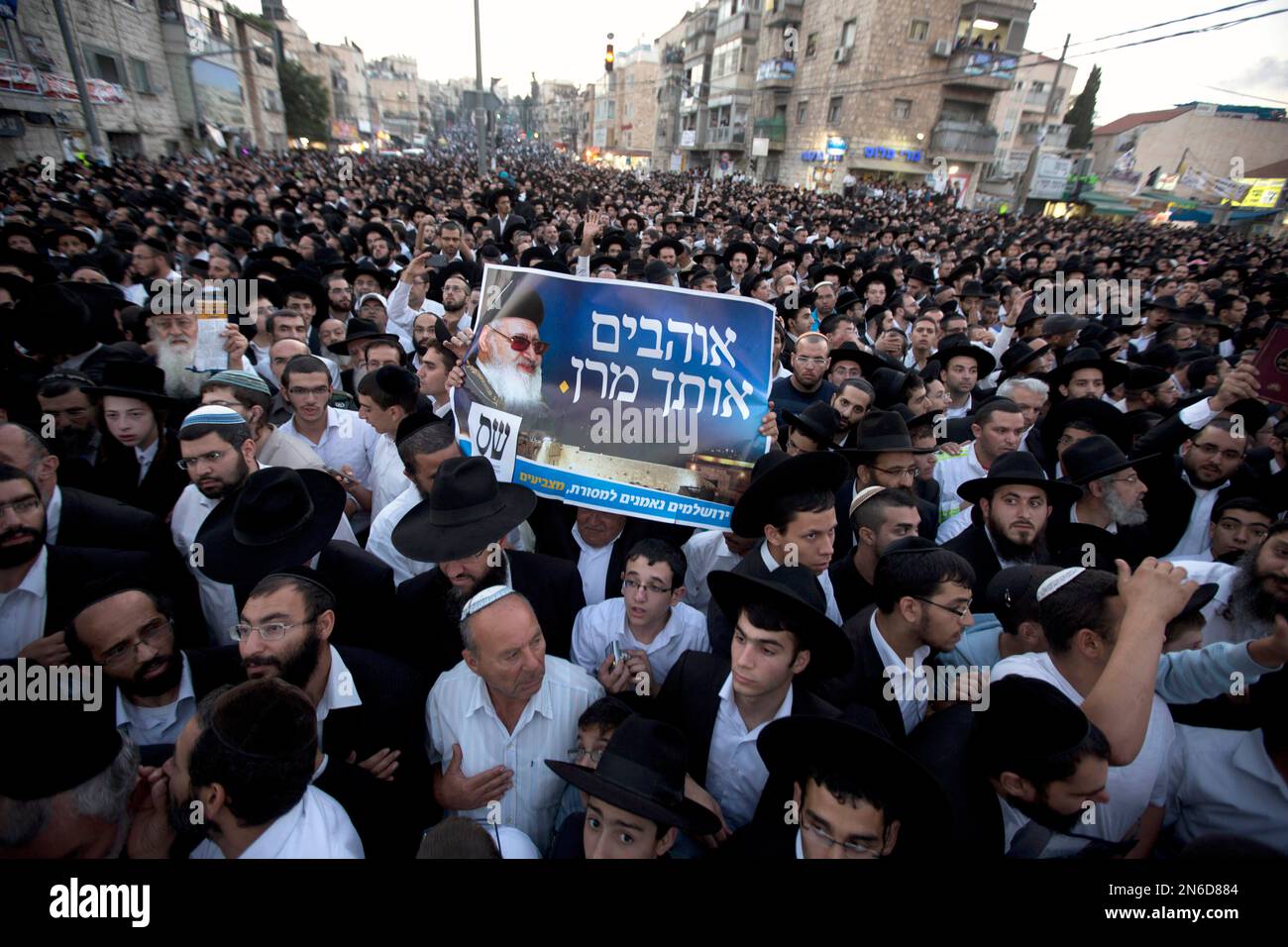An ultra-Orthodox Jewish man holds a picture of the late religious ...