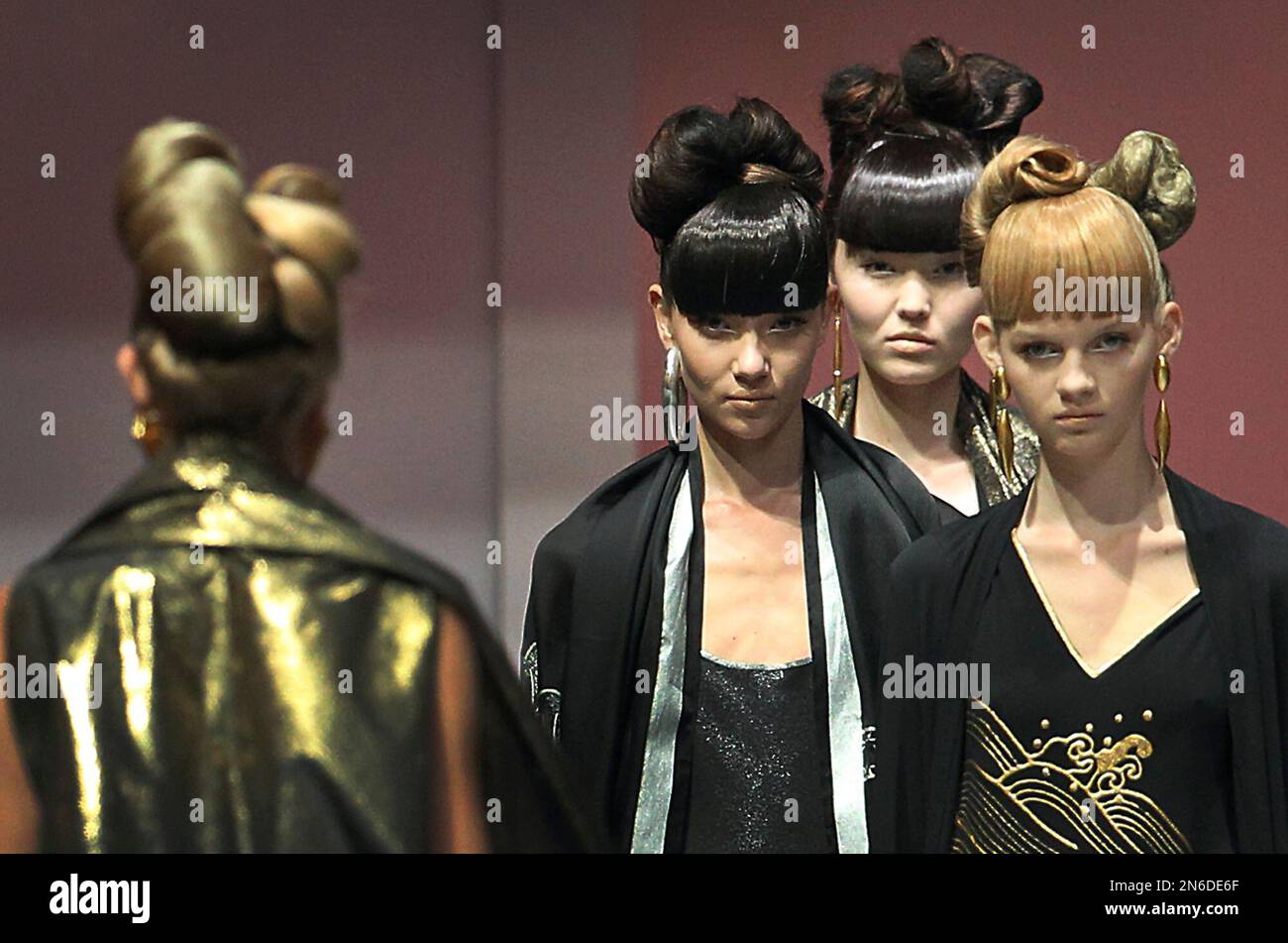 Models pose on a runway as they showcase outfits by Japanese fashion ...