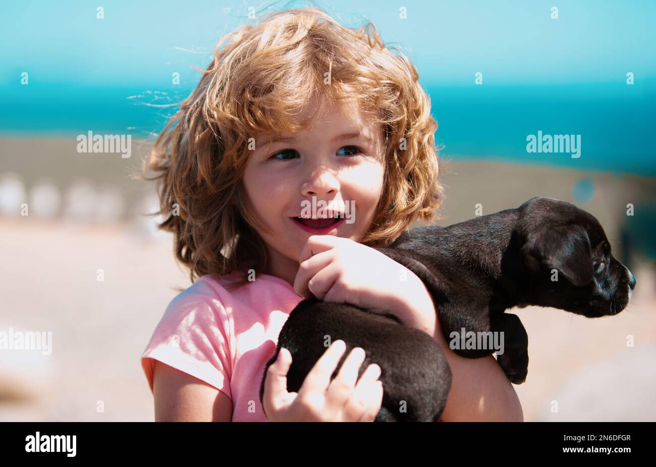 Happy child with puppy dog. Portrait kids boy with pet playing outside ...