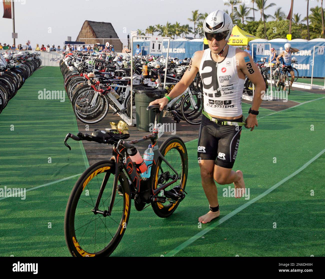 Competitor Pedro Gomes, of Portugal, runs with his bicycle on the ...