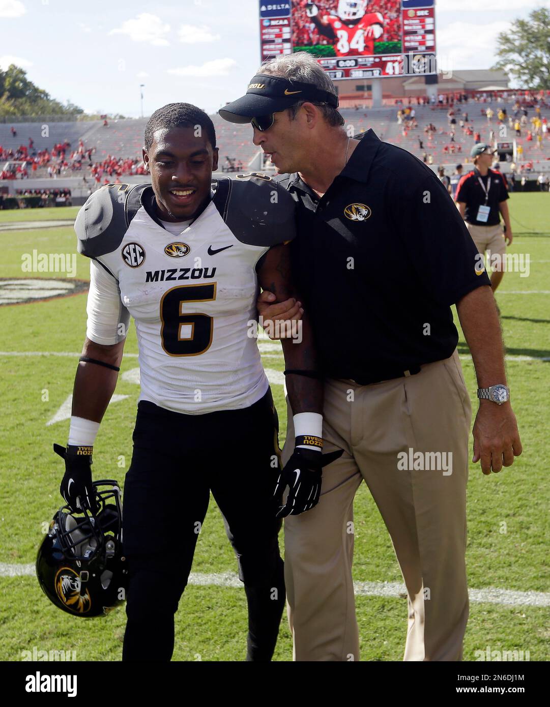 Missouri running back Marcus Murphy walks off the field with head coach ...