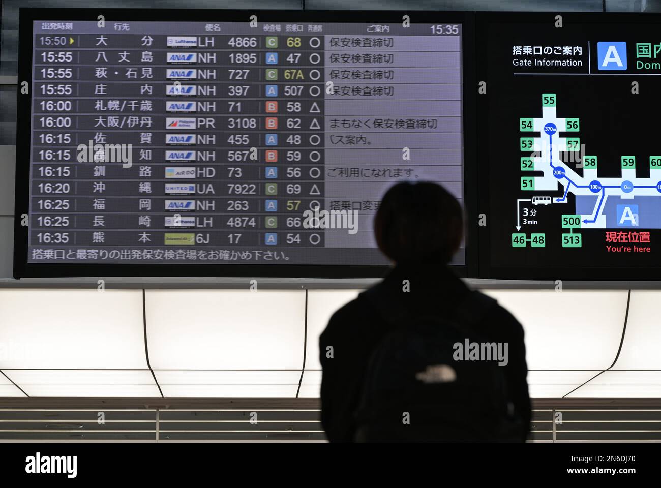 A person checking a large information display at security checkpoint A ...