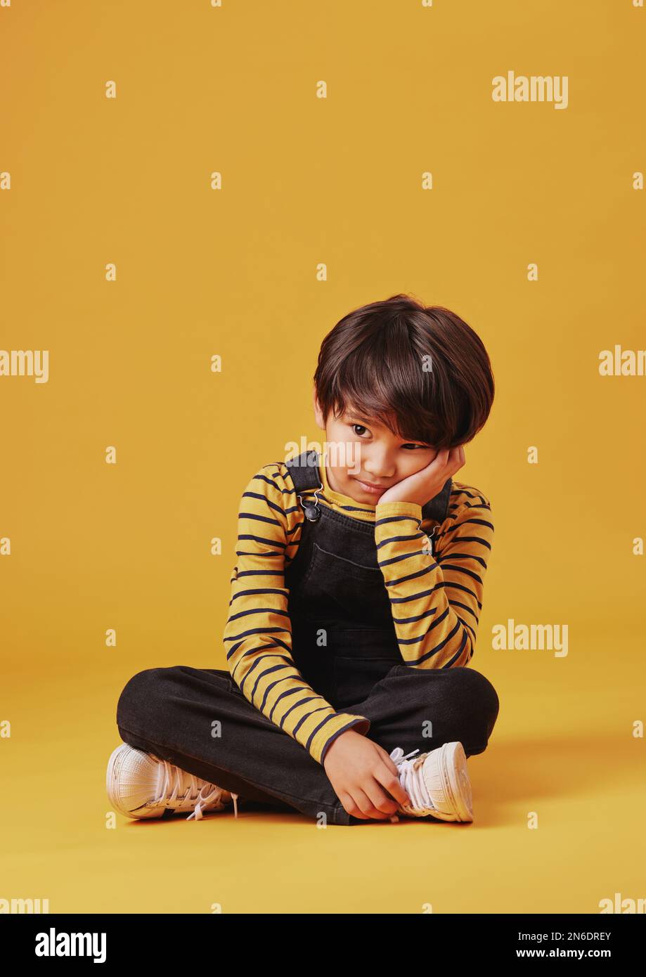 One asian boy looking sad and depressed while sitting on the floor and ...