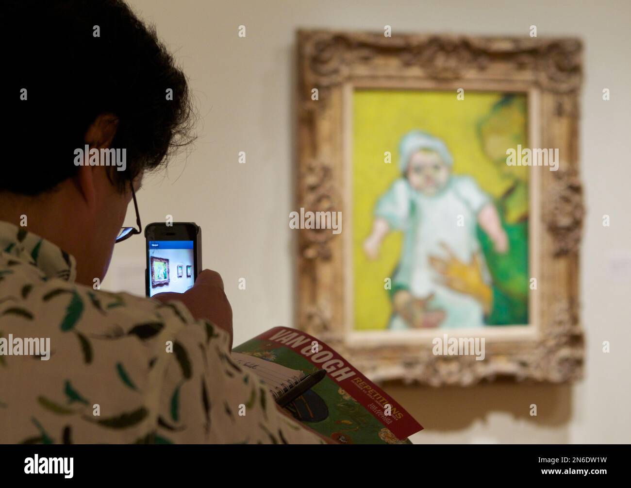 A member of the media photographs a Vincent van Gogh piece on display ...