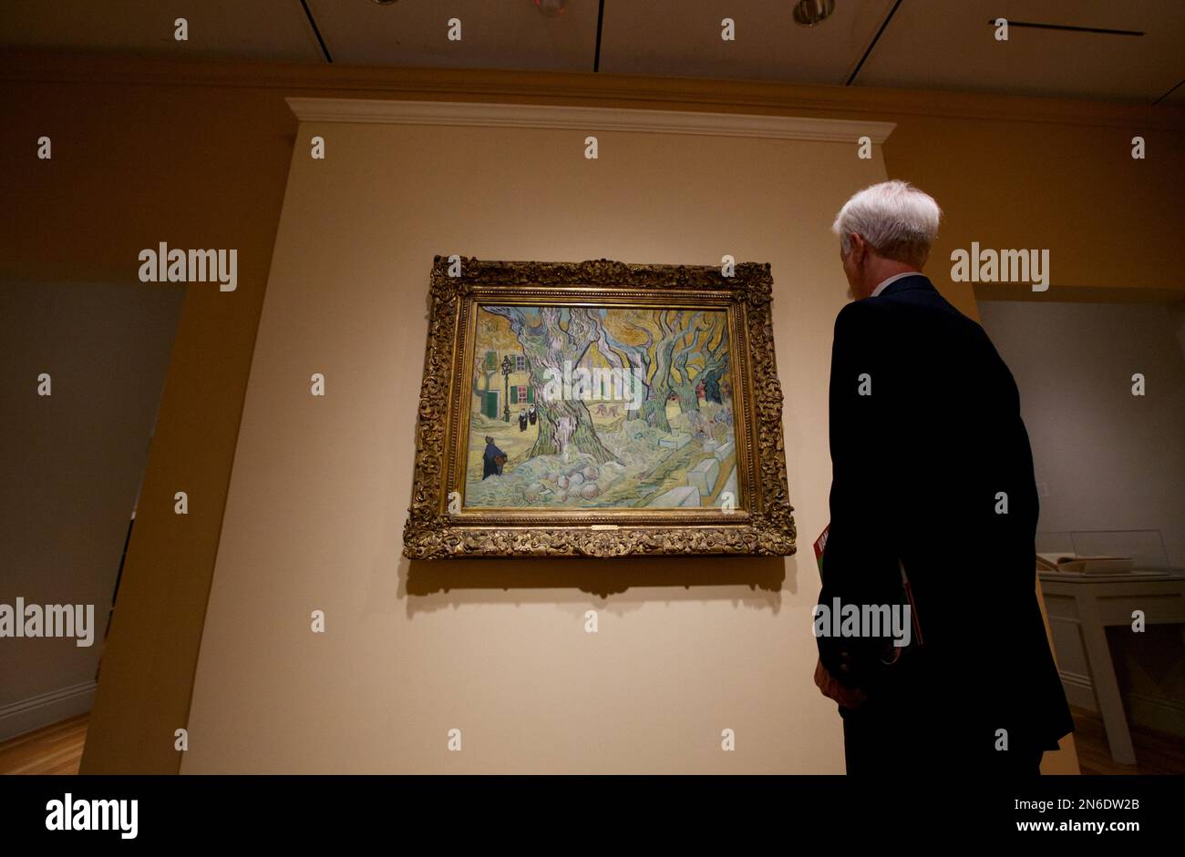 A visitor looks at Vincent van Gogh's "The Road Menders," on display at ...