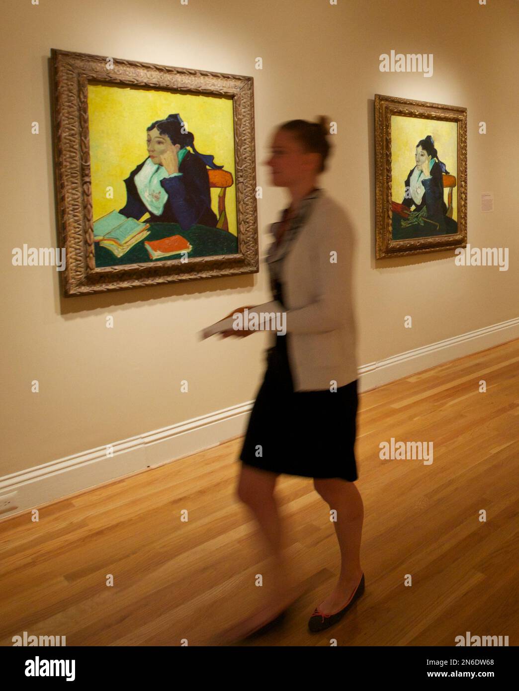A woman walks past repetitions of Vincent van Gogh's "L'Arlesienne ...
