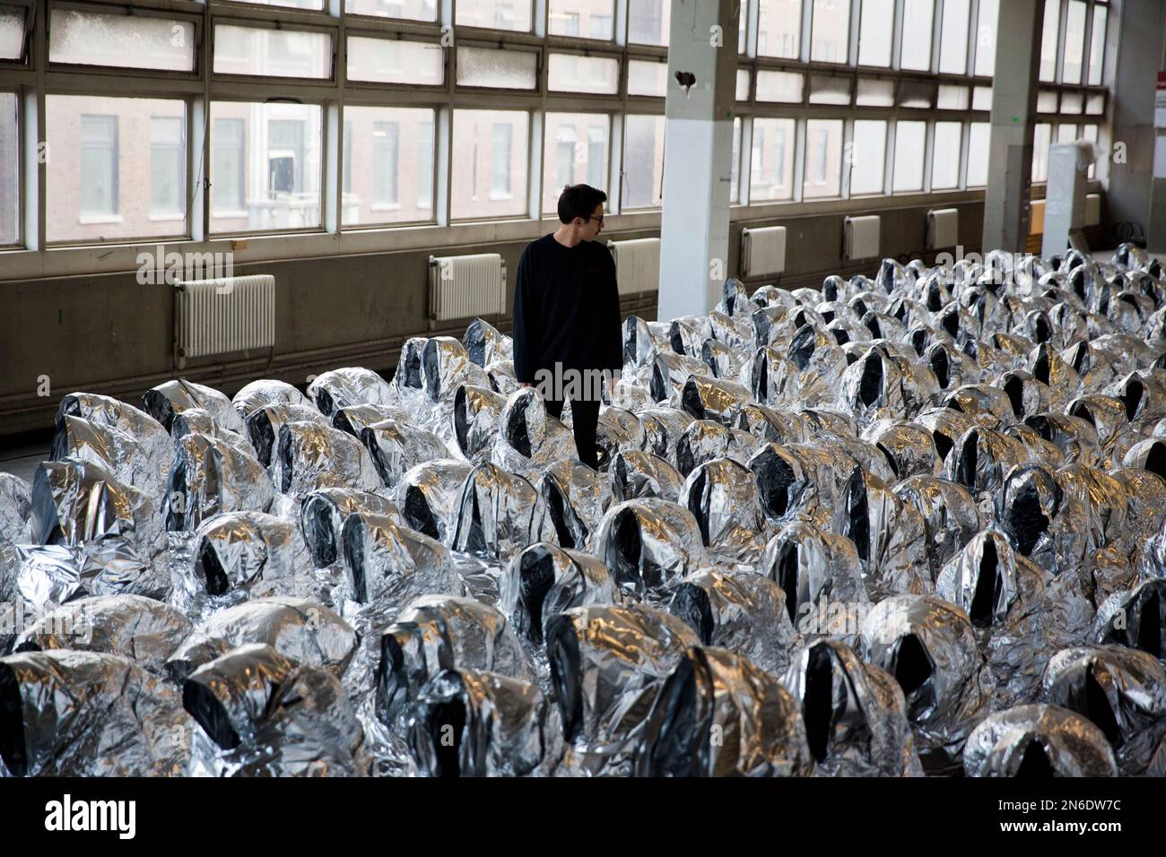 A man poses for photographs amongst Algerian and French artist Kader ...