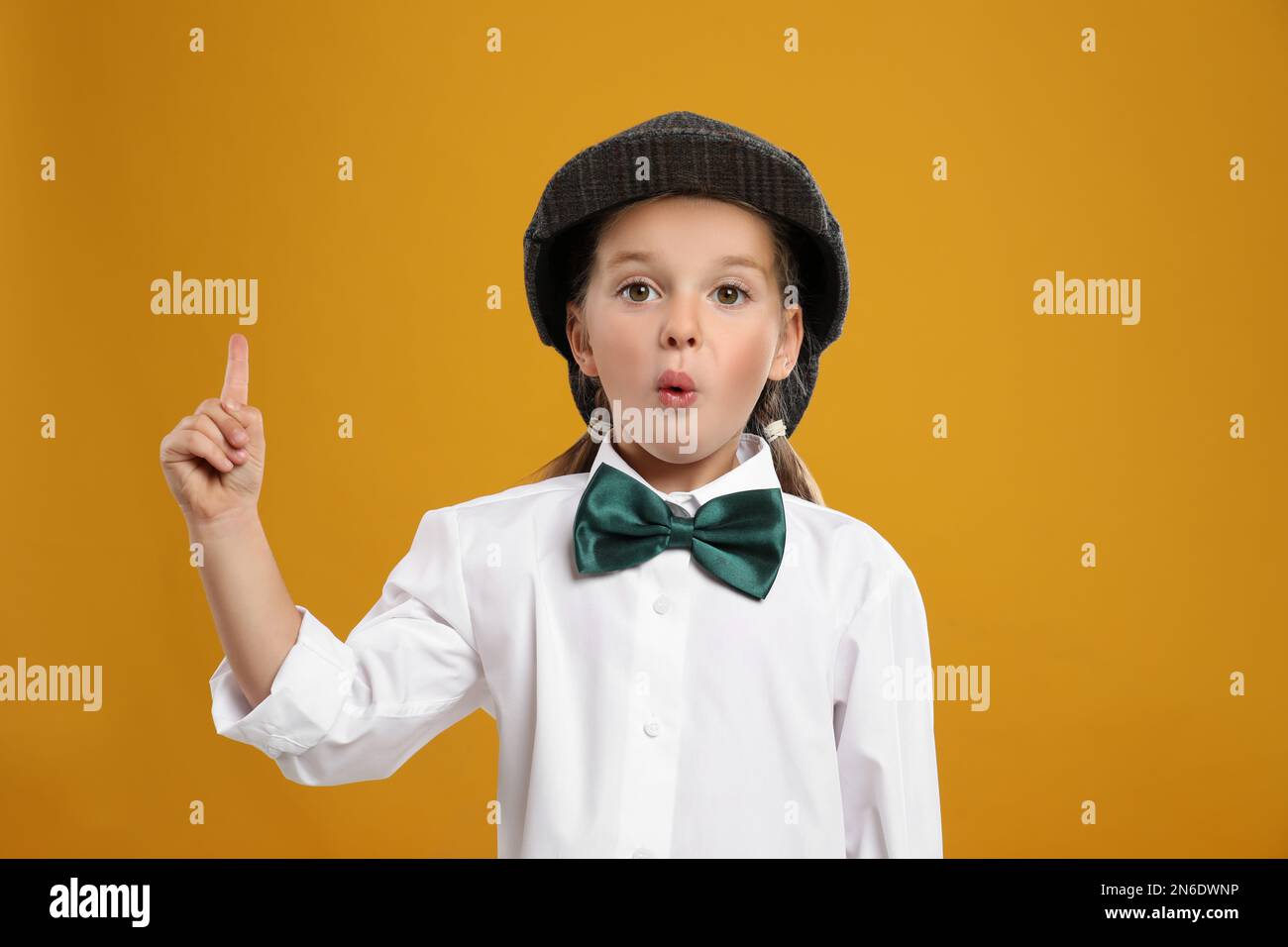 Cute little detective in hat on yellow background Stock Photo - Alamy