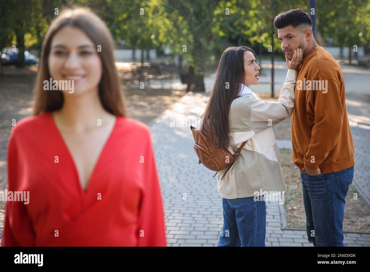 Disloyal man looking at another woman while walking with his girlfriend ...