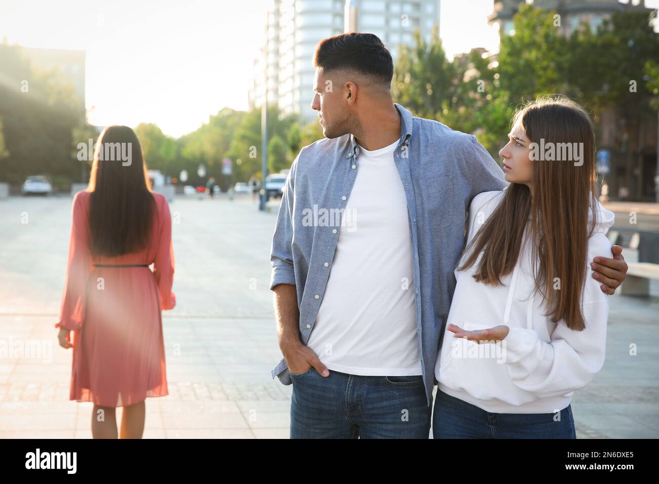 Disloyal man looking at another woman while walking with his girlfriend ...