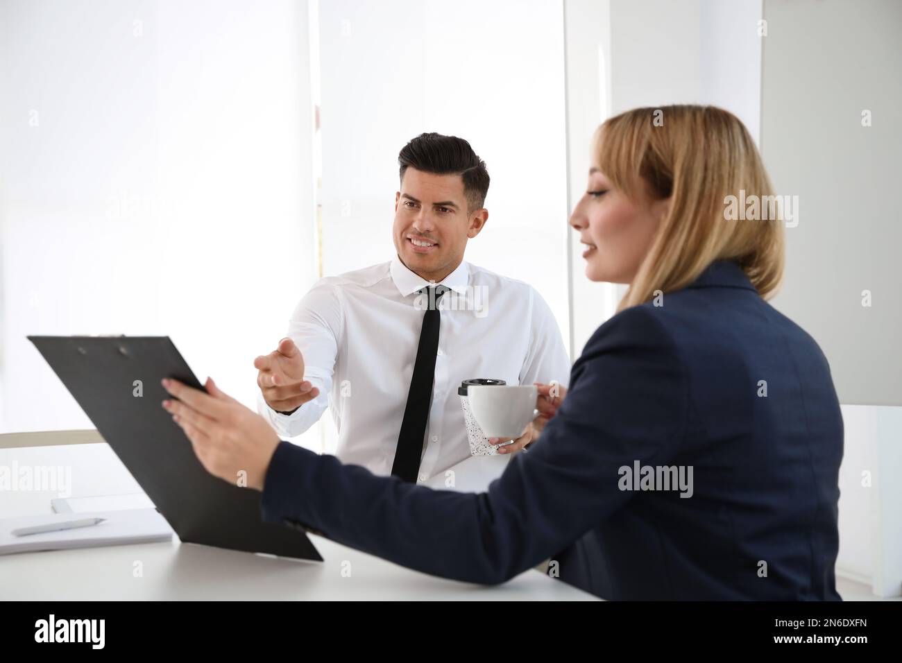 Office employees talking at table during meeting Stock Photo - Alamy