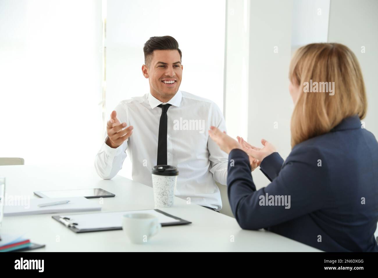 Office employees talking at table during meeting Stock Photo - Alamy