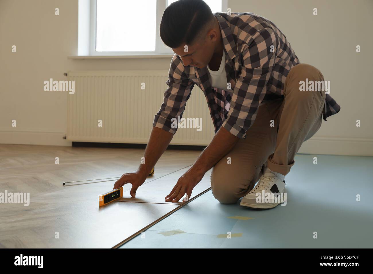 Professional worker installing new parquet flooring indoors Stock Photo ...