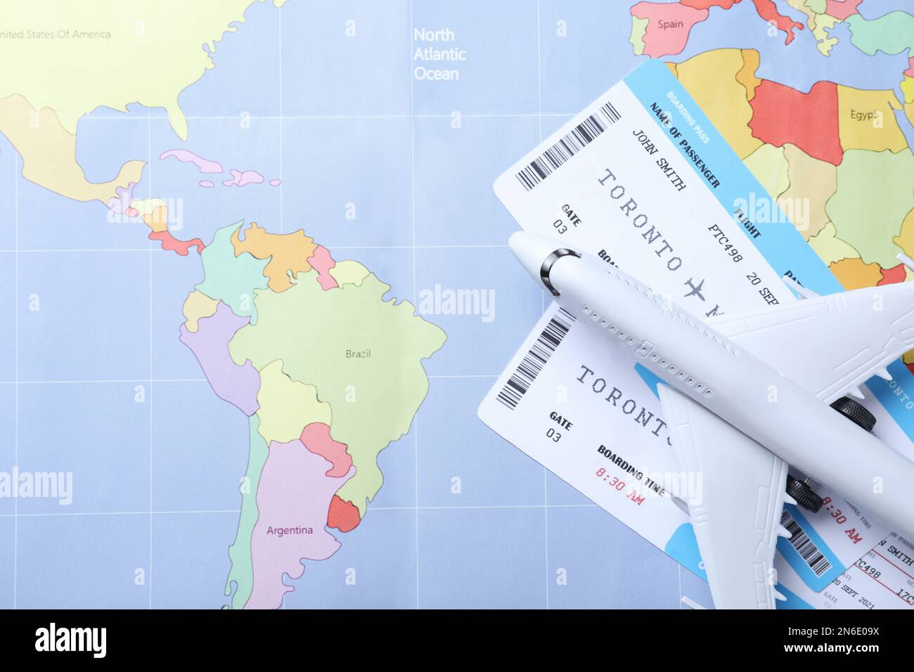 Toy airplane and tickets on world map, flat lay. Travel agency concept ...