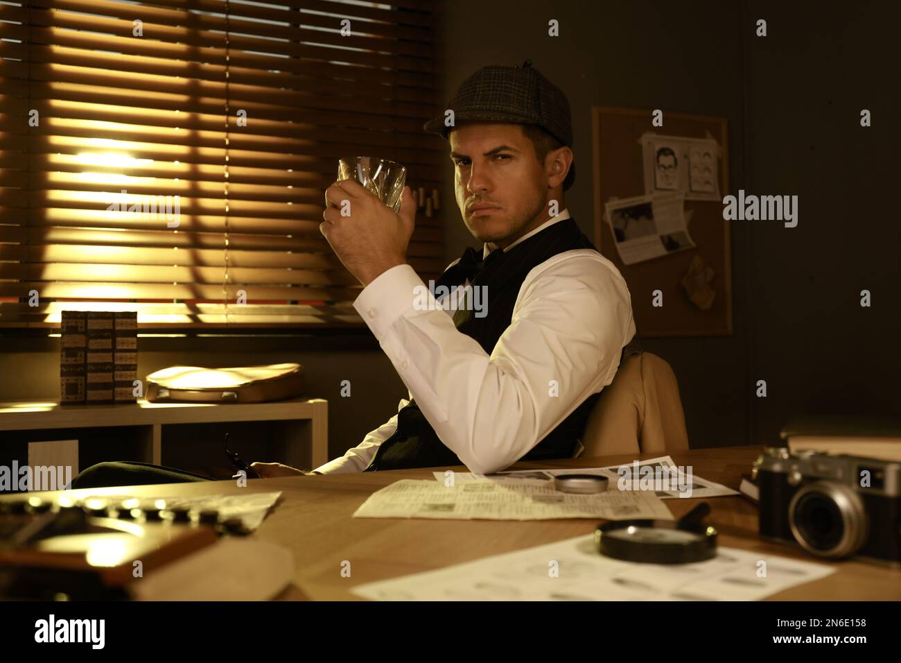 Old fashioned detective with drink at table in office Stock Photo - Alamy