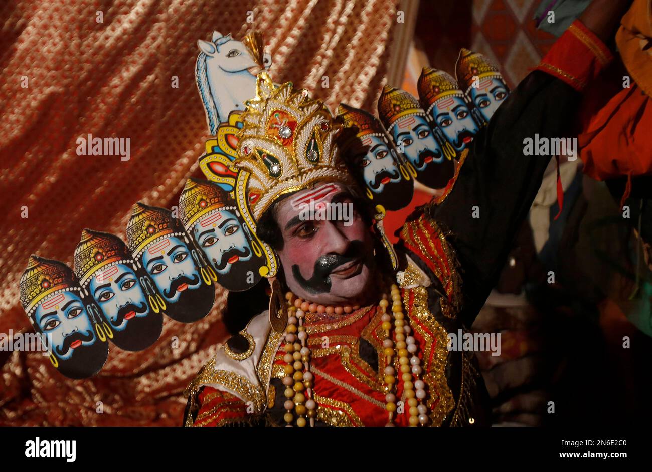 An Indian artist waits back stage dressed up as Ravana for "Ramlila", a ...