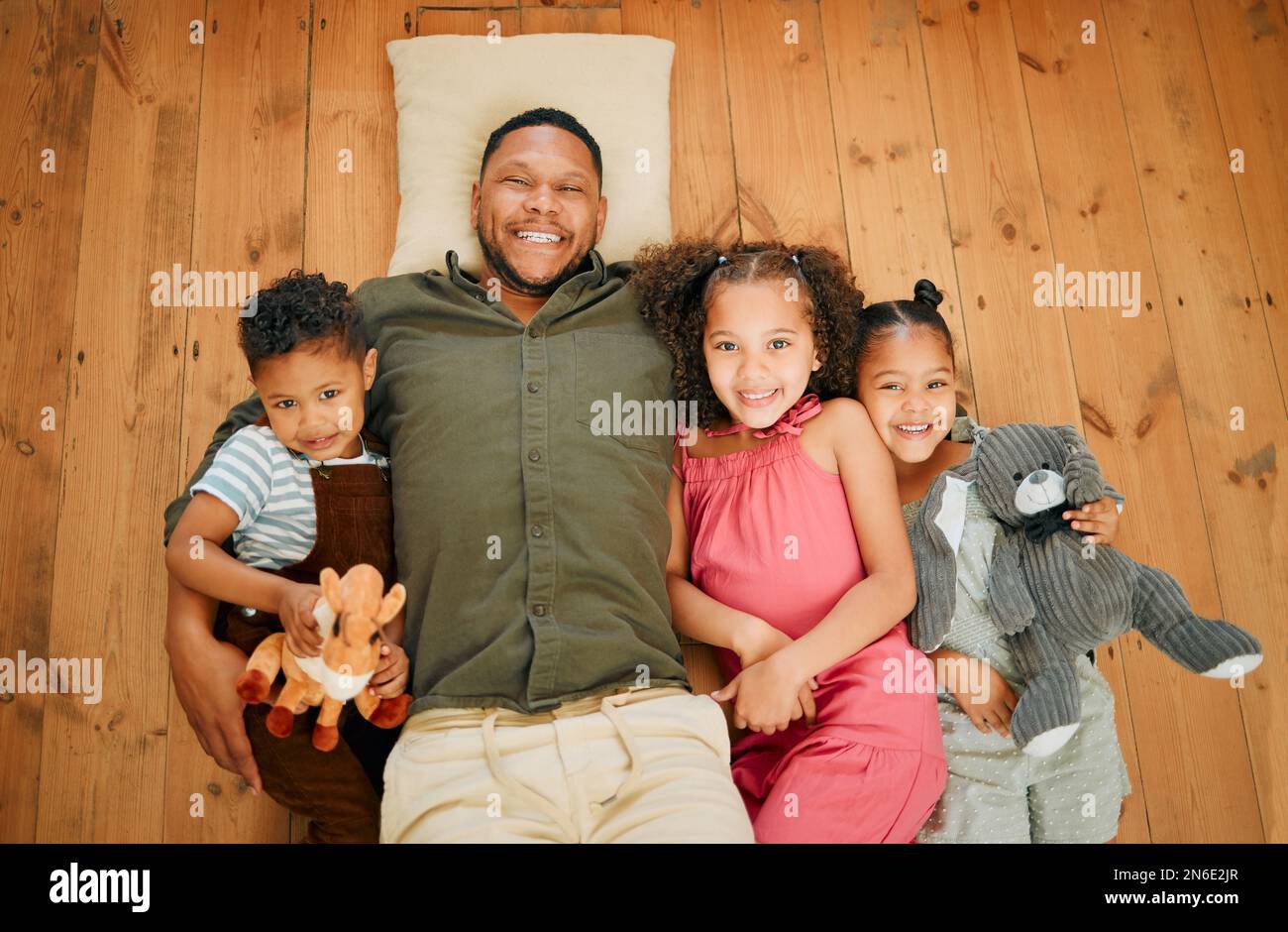 A happy mixed race family of four relaxing and lying on the lounge ...