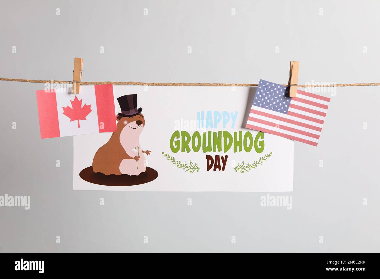 Happy Groundhog Day greeting card and flags hanging on light background ...