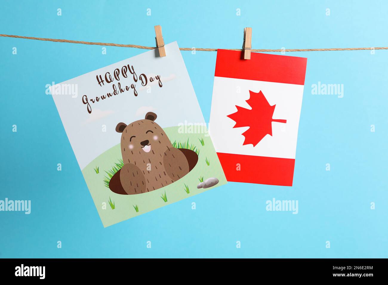 Happy Groundhog Day greeting card and Canada flag hanging on light blue ...