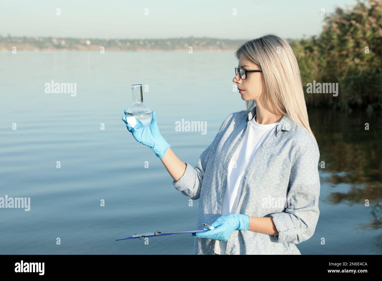 Scientist with clipboard and sample taken from river Stock Photo - Alamy