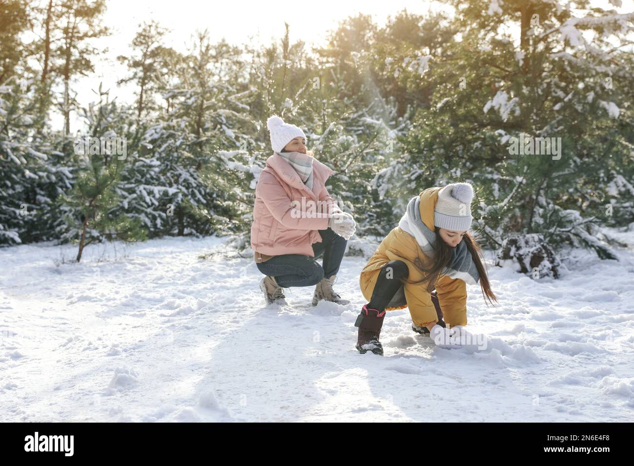 Mother and daughter rolling snowballs in winter forest Stock Photo - Alamy