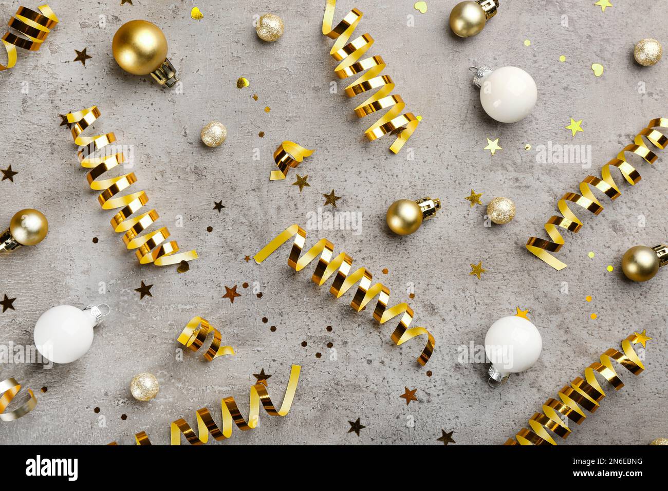 Shiny serpentine streamers and Christmas balls on grey background, flat ...