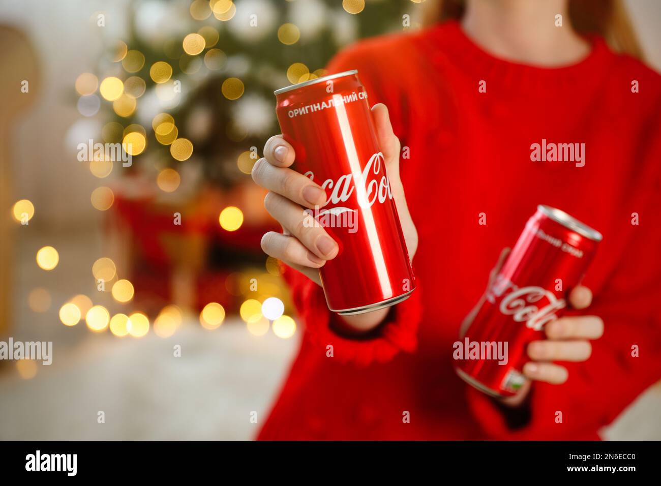 MYKOLAIV, UKRAINE - January 01, 2021: Woman with cans of Coca-Cola ...