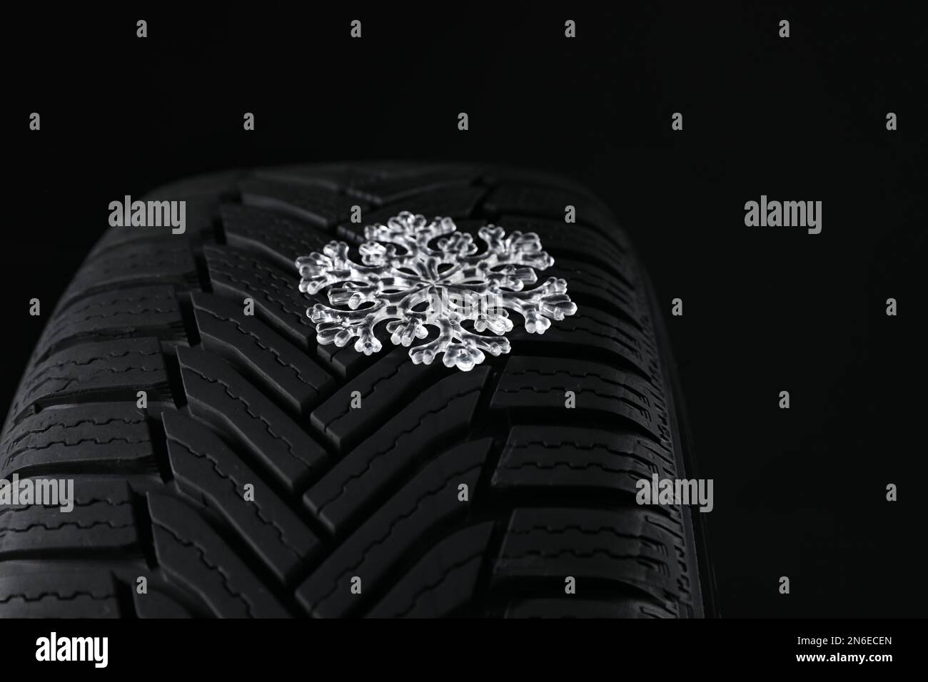 Winter tire with icy snowflake on black background, closeup Stock Photo ...