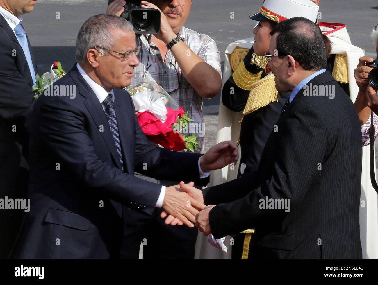 Tunisian Prime Minister Ali Larayed, right, greets his Libyan ...