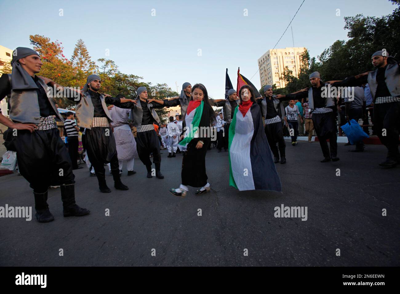 Palestinian youths dressed in traditional attire perform a traditional ...