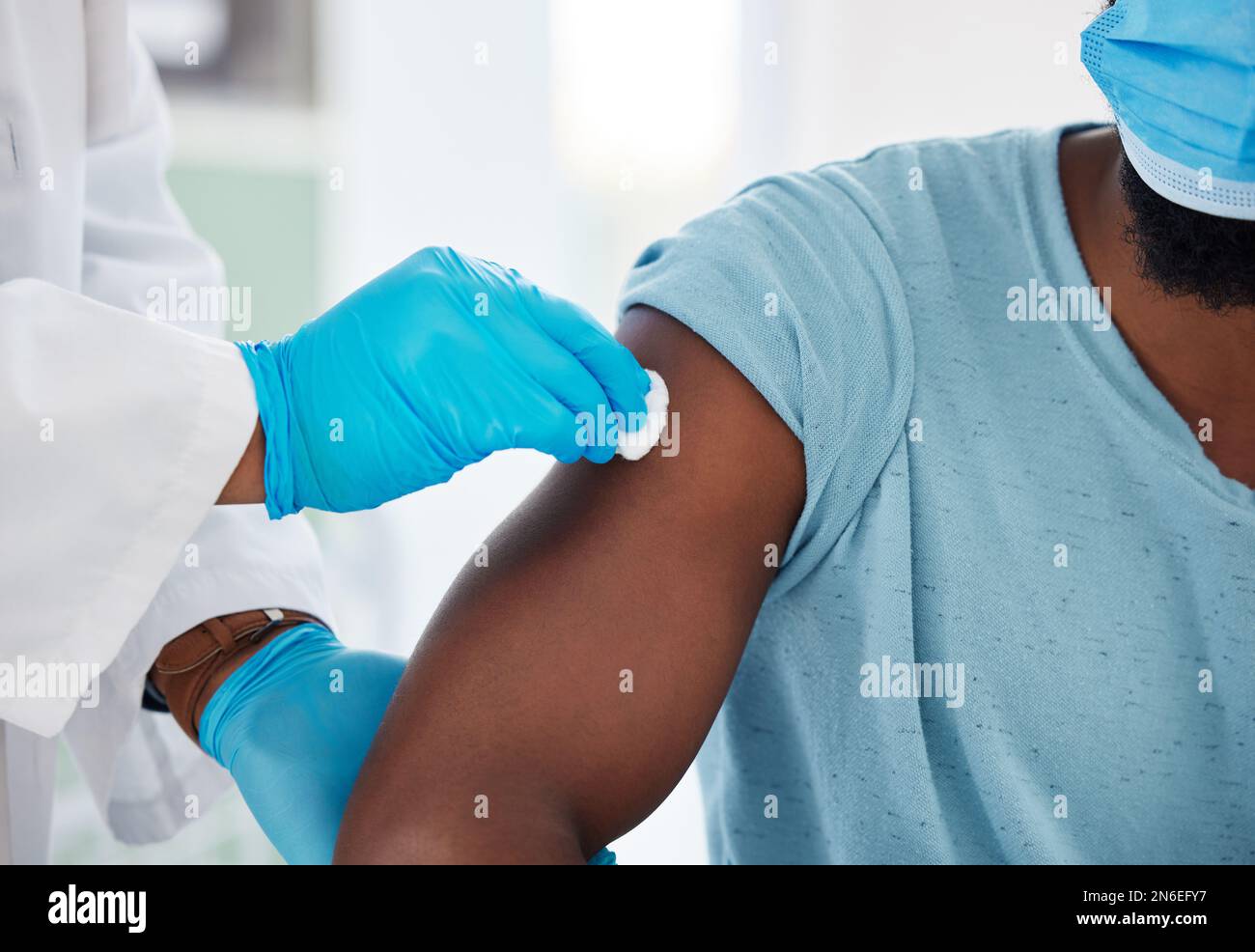 Closeup of doctor cleaning the arm of a patient. Doctor using cotton ...