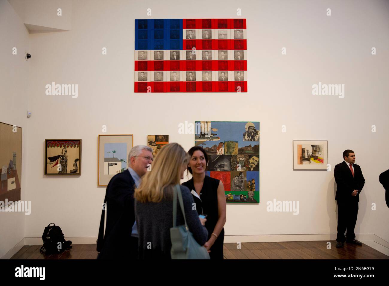 People stand near works including at top "The Presidential Suite: JFK ...