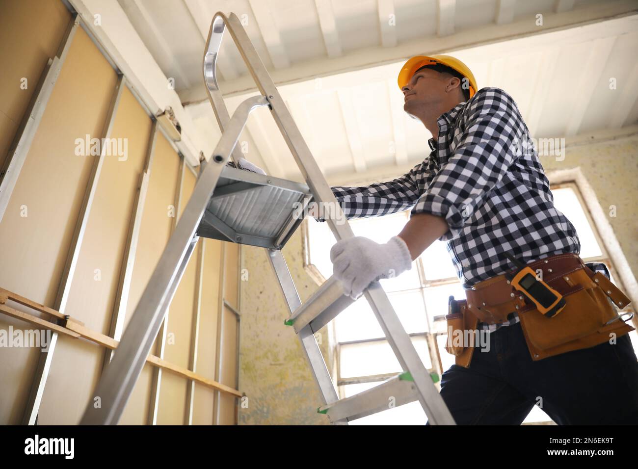 Professional constructor on ladder in old building Stock Photo - Alamy