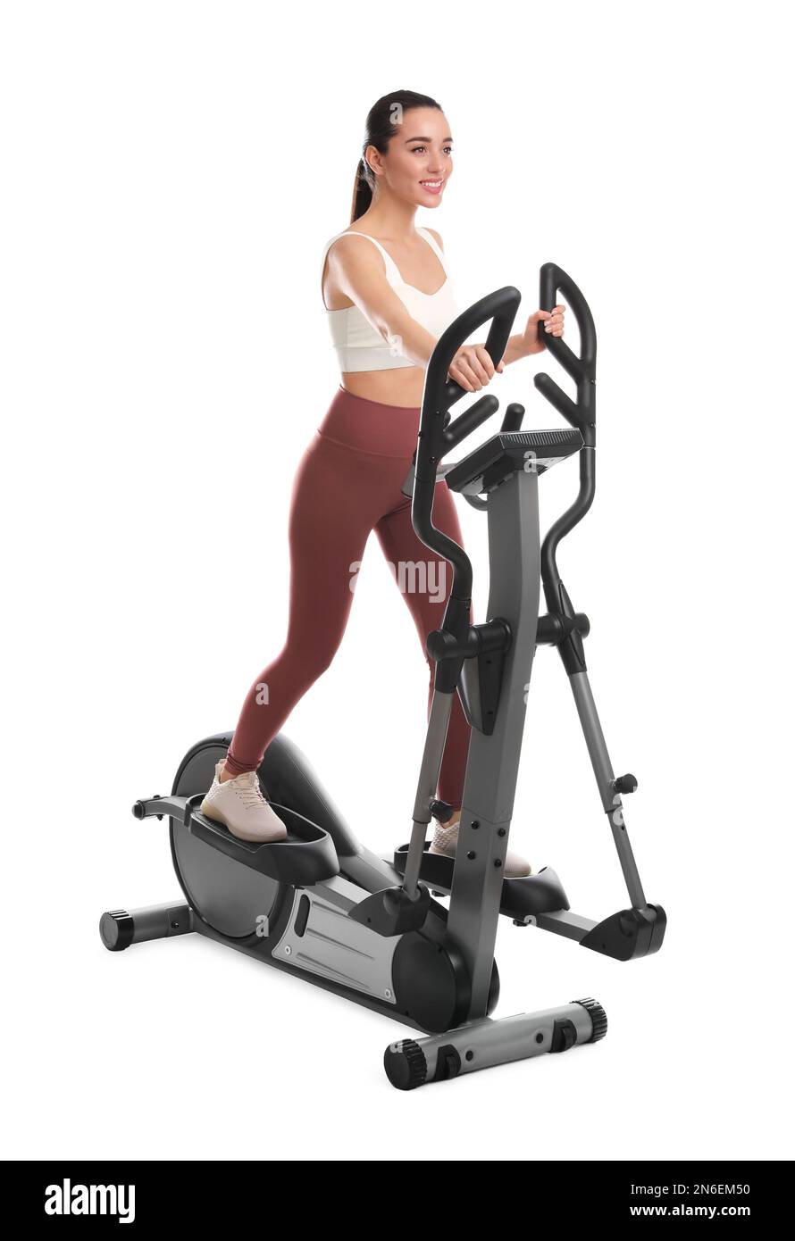 Woman using modern elliptical machine on white background Stock Photo ...